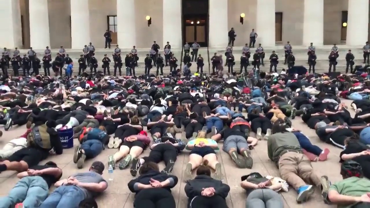Protesters lay flat on the ground at the Ohio Statehouse in Columbus ...