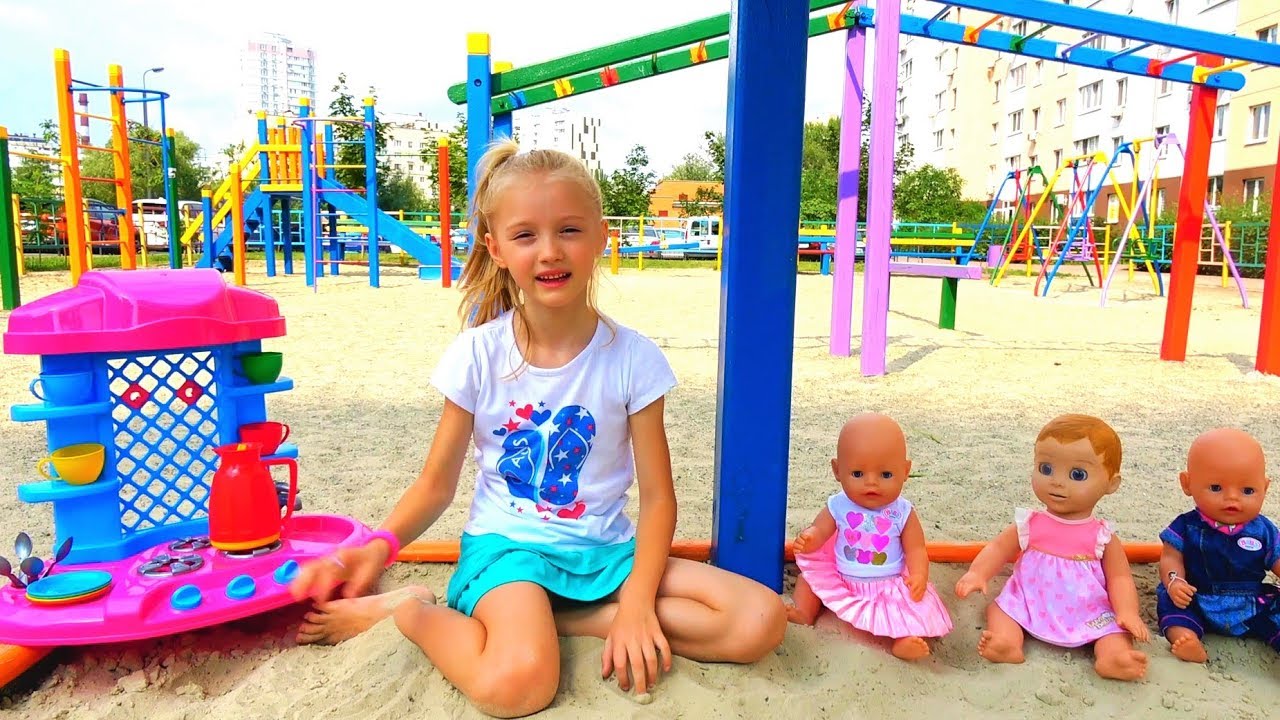 Funny Polina playing with Colored cups and baby dolls on the playground ...
