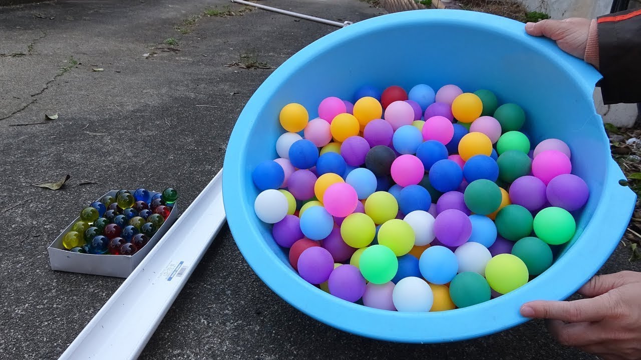Marble run race - rain gutter + big colorful ball + sandy beach tunnel ...