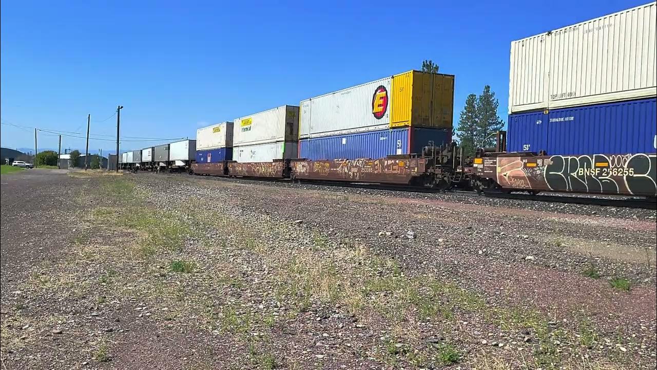 Super long BNSF Intermodal train passes through Columbia Falls montana with warbonnet trailing ...