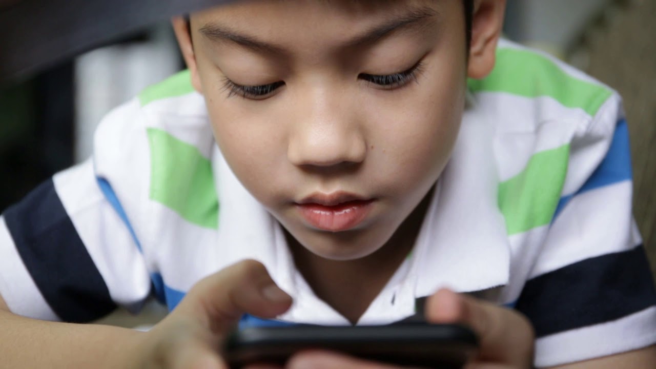 asian child using a digital cell phone while lying down on couch - YouTube