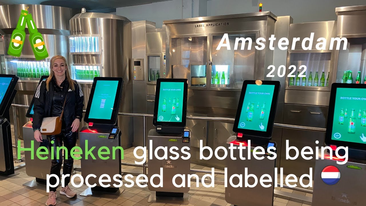 Heineken glass bottles being processed and labelled during the beer ...