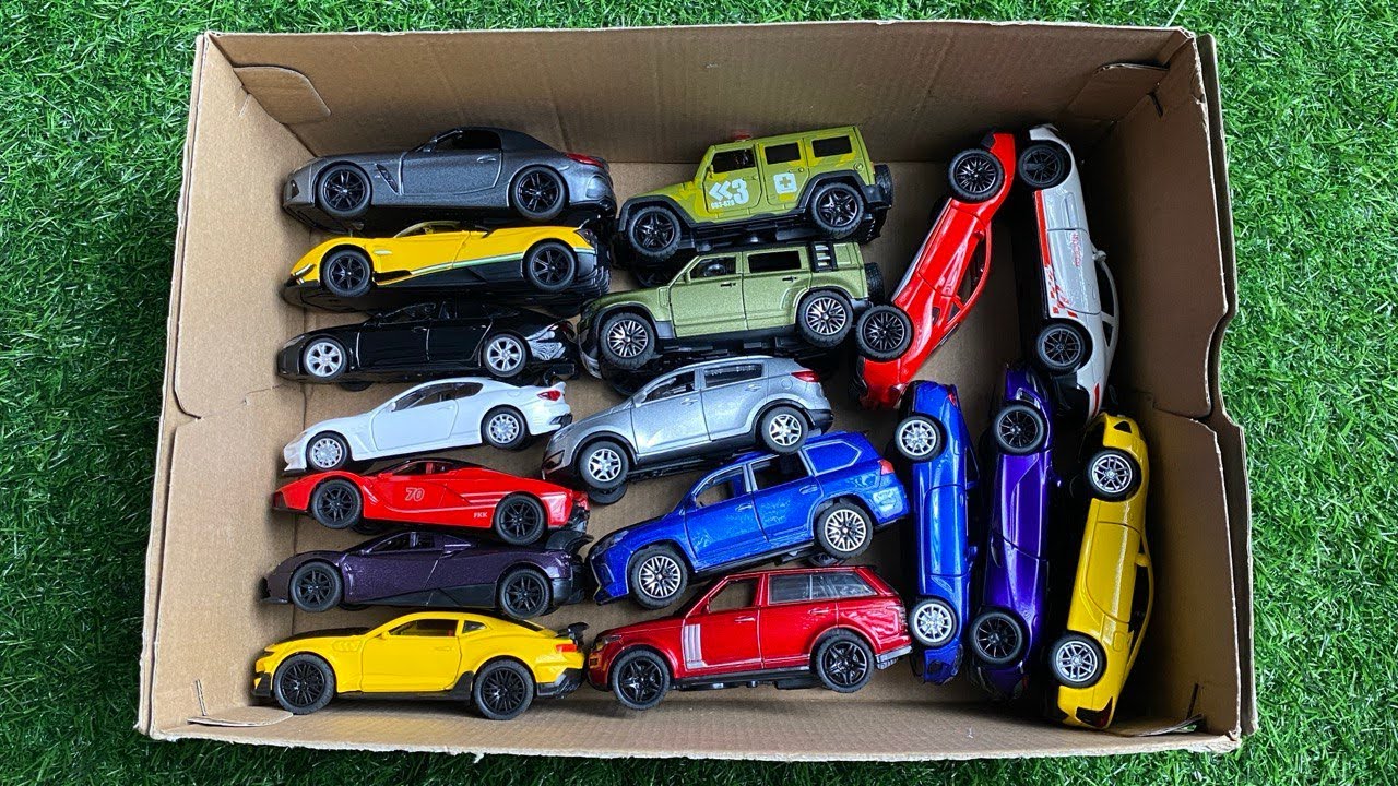 Box full of various miniature cars Pagani, Dodge, Rav4, DHL, Volkswagen ...