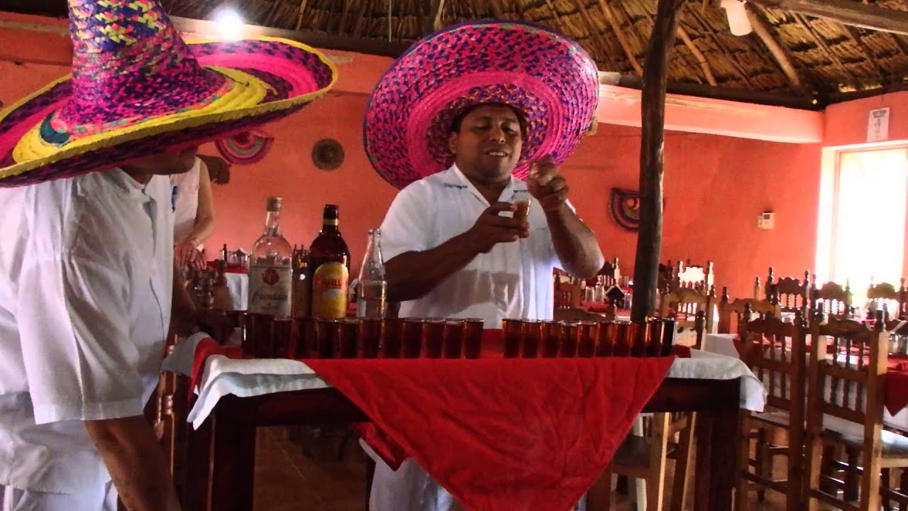 Lustiger mexikanischer Kellner mixt La Cucaracha Cocktail aus Tequila ...