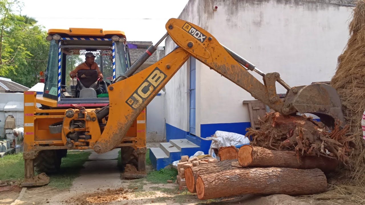 A tree root is being lifted with Jcb 3dx Machine in a village house ...