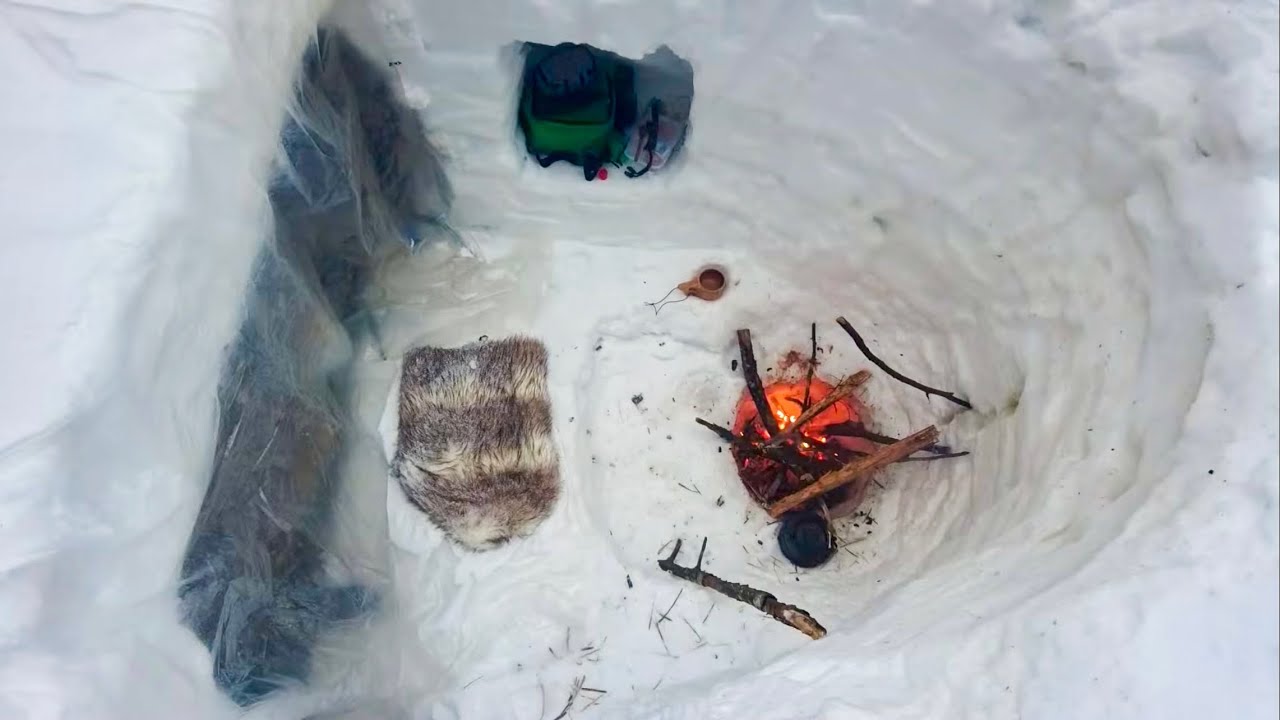 Winter camp under three meters of snow in the wild forest. Overnight ...