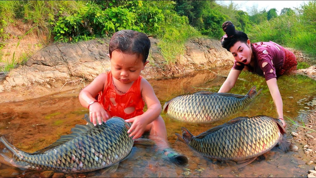 Mother and young son discover fruits savour and cook fresh fish caught ...