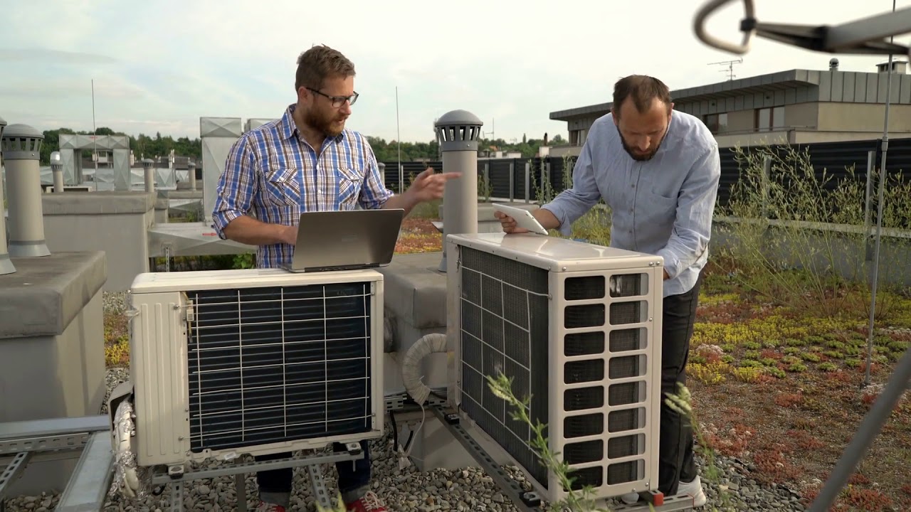 two men working on the air condition while standing on the roof - YouTube