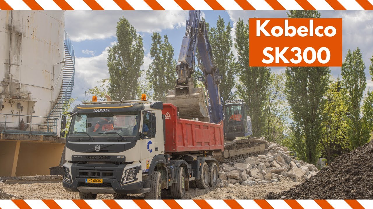 Big blue Kobelco SK300 loading trucks with material - YouTube