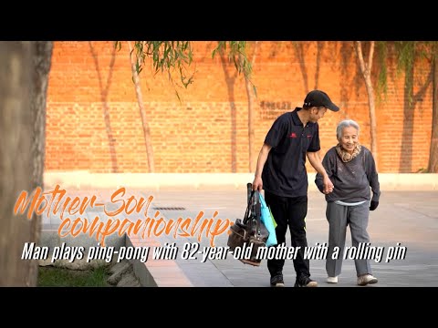 Mother-son companionship: Man plays ping-pong with 82-year-old mother using a rolling pin