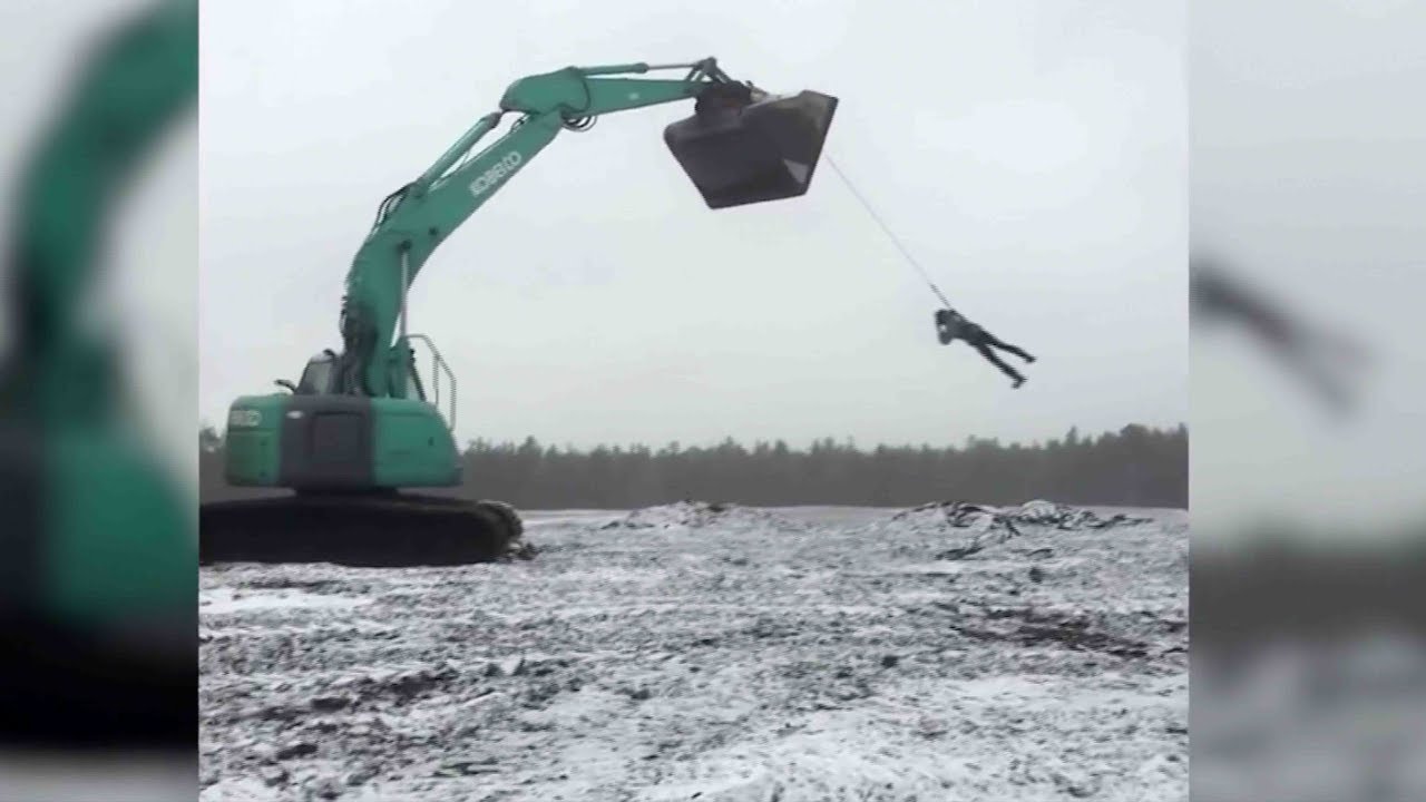 Man performs crazy stunt harnessed to excavator - YouTube