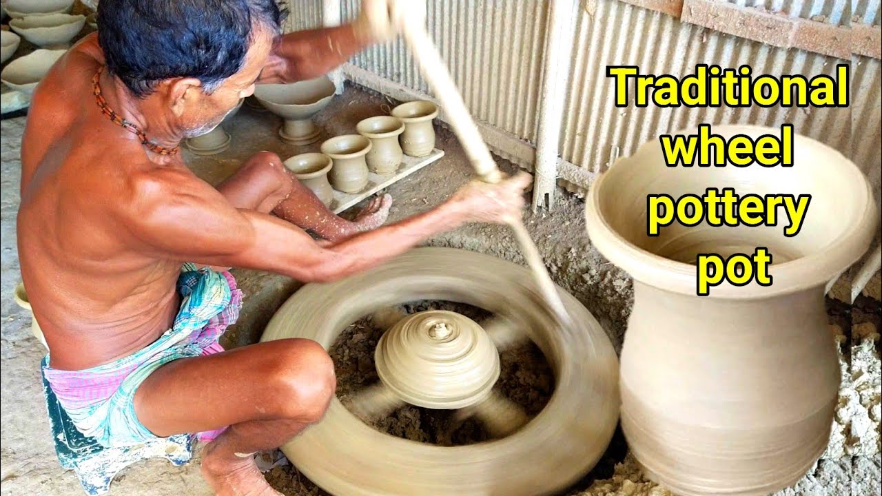 Making a traditional wheel pottery pot. Ancient style wooden wheel clay ...