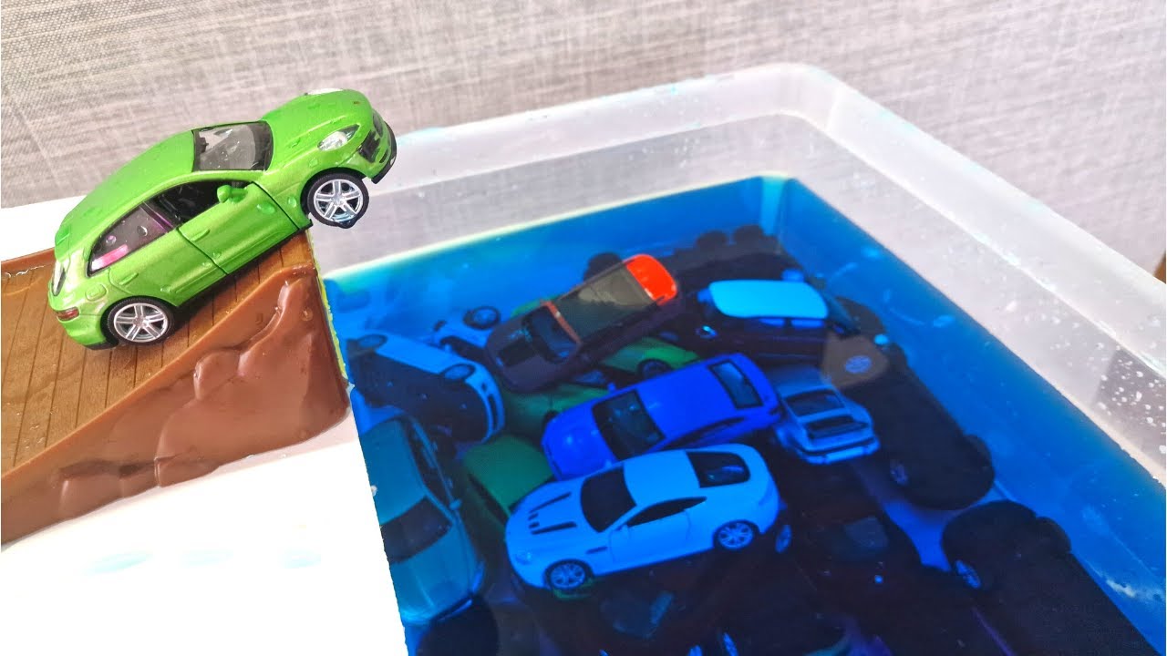 Cars jumping over a ramp and falling into blue water - YouTube