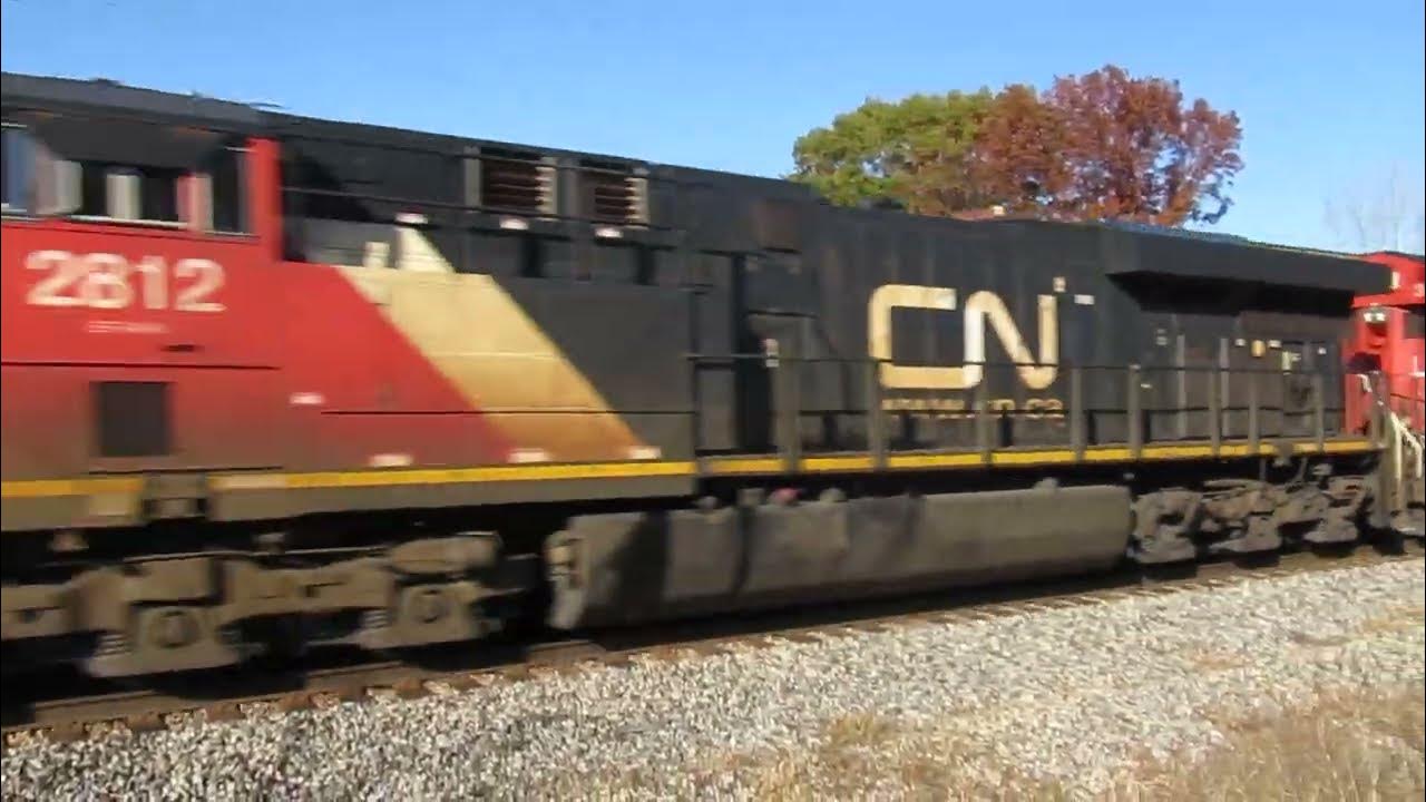 CN 3133, 2812 slip an Eastbound freight train with CMO, UP, WC covered hoppers past Vicksburg ...