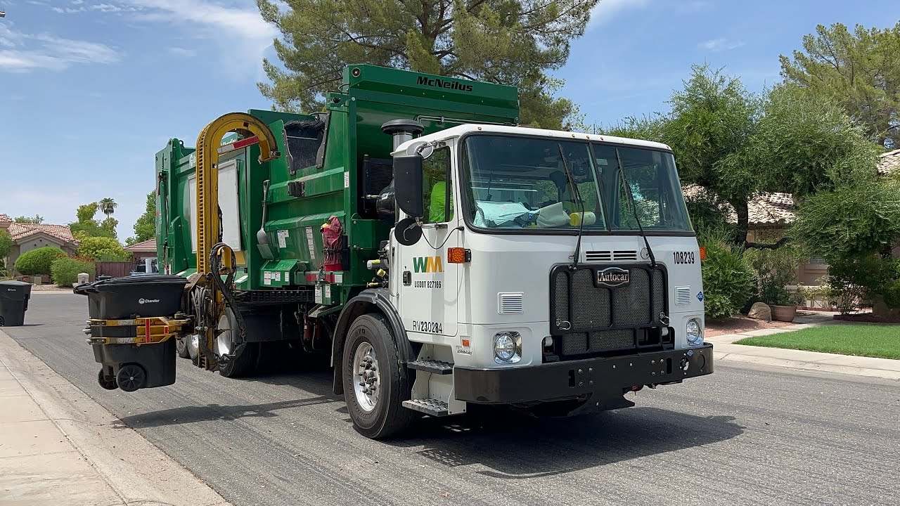 Waste management brand new garbage truck with a fast driver behind the ...