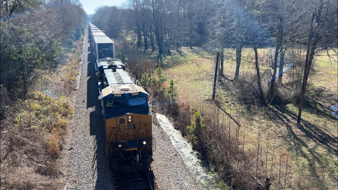 Aerial of CSX 3125 & Rear DPU CSX 3191 moving heavy cargo containers ...