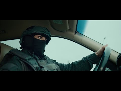 A masked female agent in tactical gear