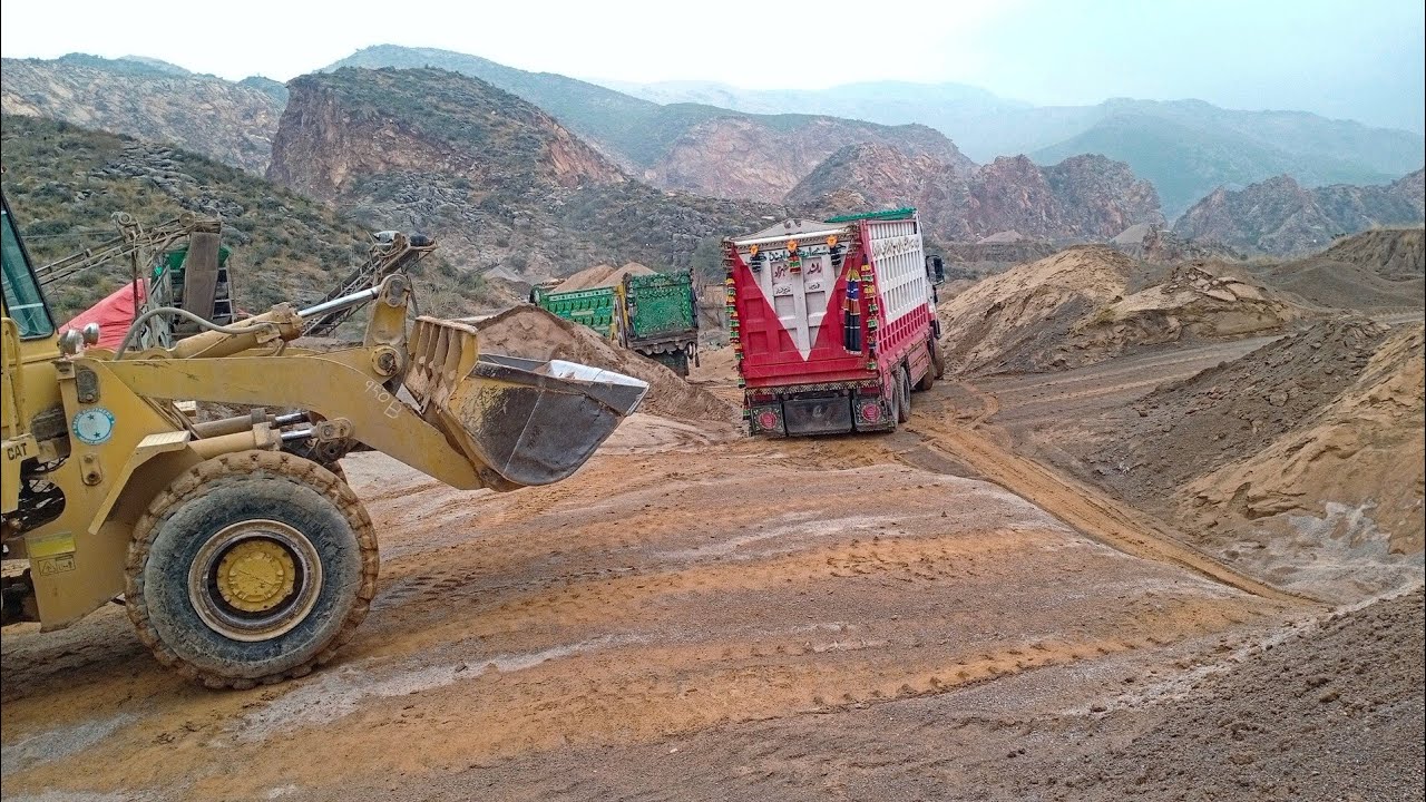 Caterpillar wheel loader 966F is loading dumptruck with stone crush ...