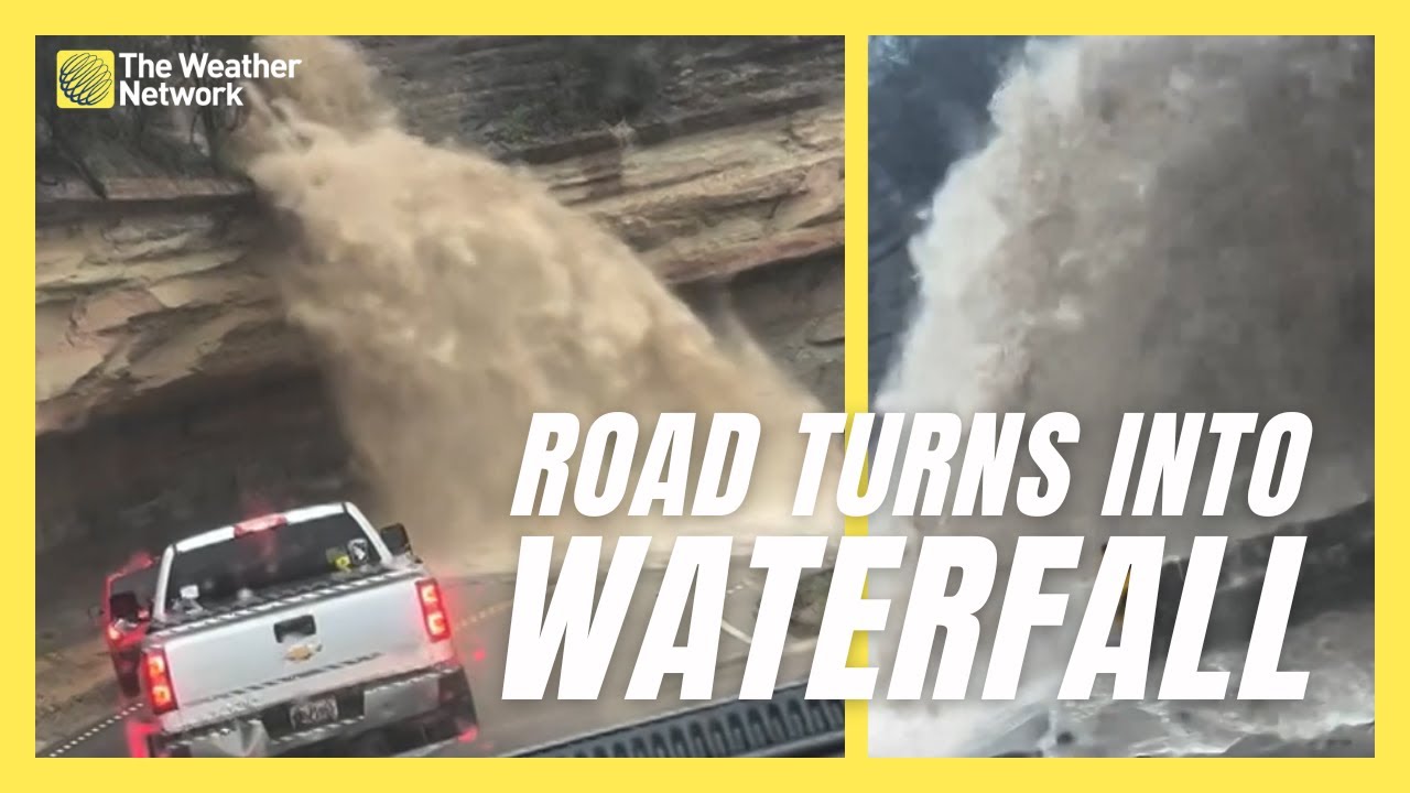 "That's scary!" Floodwaters Create a Gushing Waterfall Onto Road - YouTube
