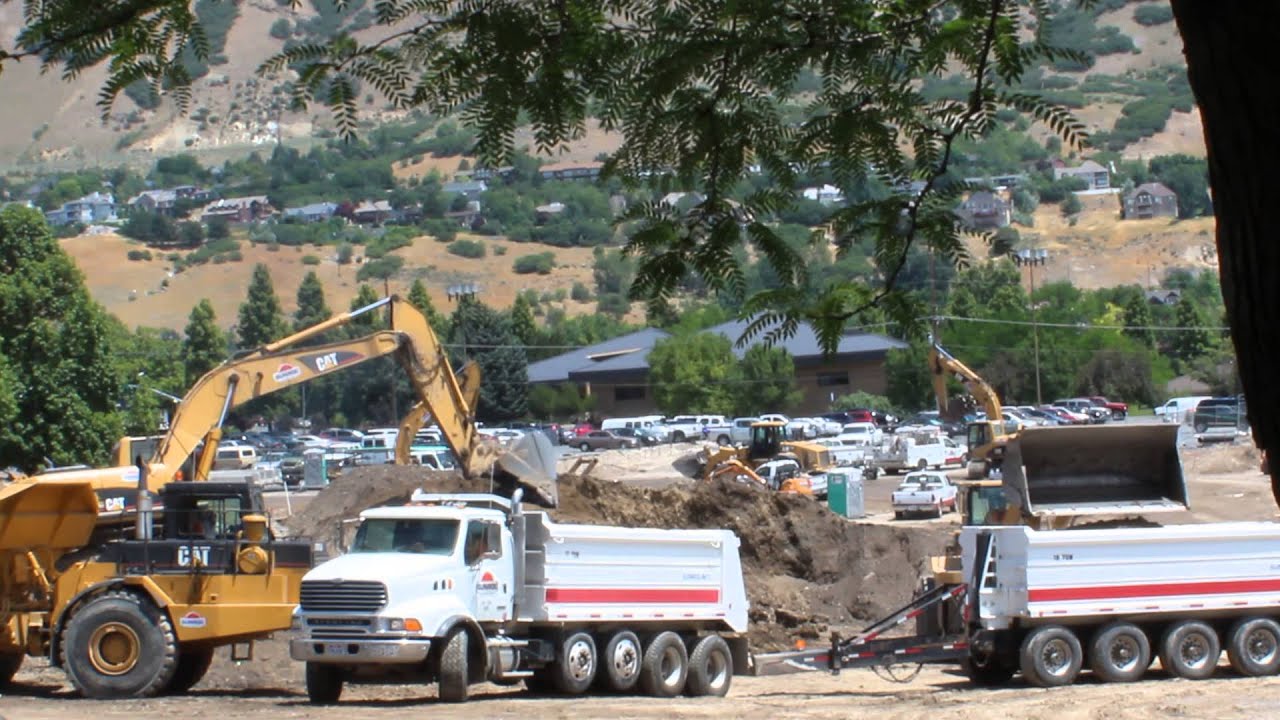 Construction Site Loader loading double dump truck excavator working ...