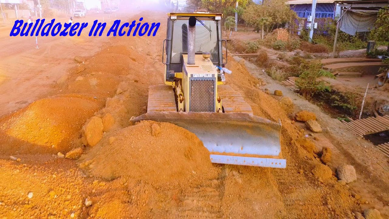 Bulldozer in action! Bulldozer in action, pushing a pile of earth with ...