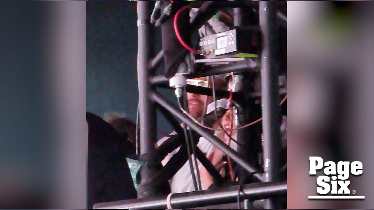 Travis Kelce protectively wraps his arms around Taylor Swift while ...