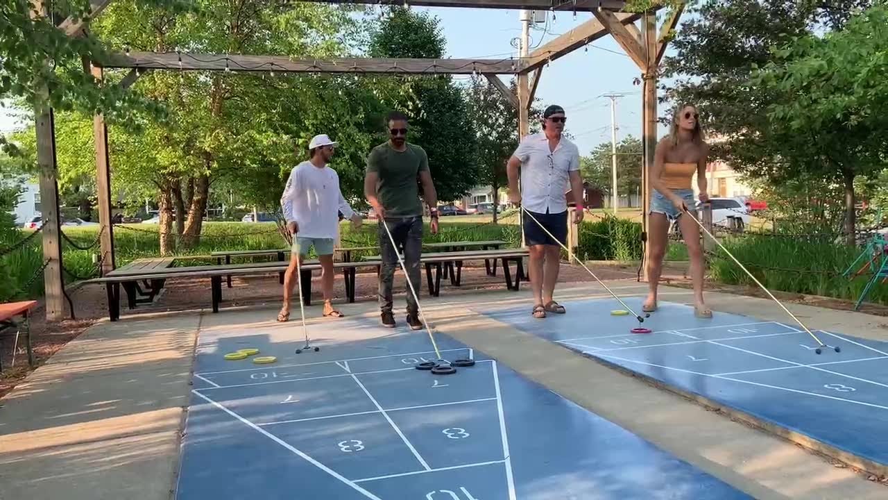 Customers enjoy shuffleboarding at Hydraulic Hearth - YouTube