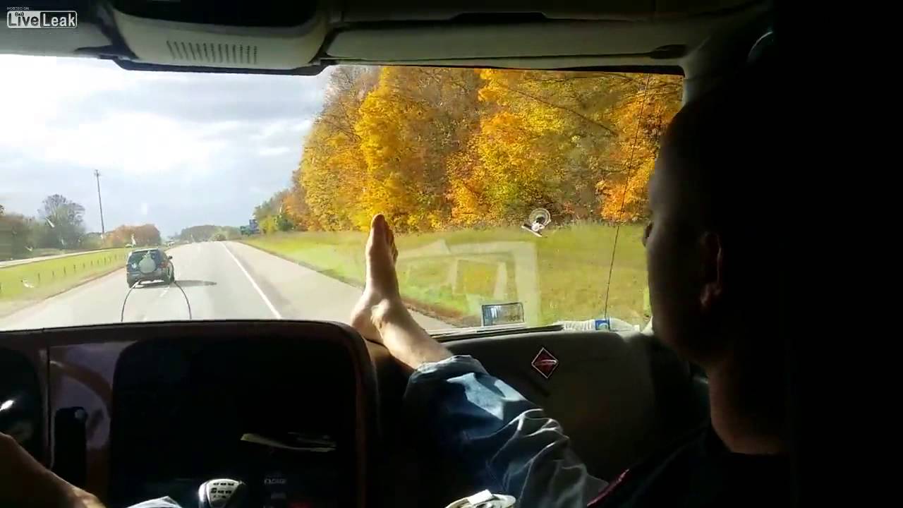 russian driver a truck in the usa driving with his feet on the highway ...