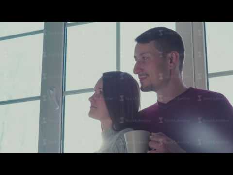 The couple standing at the window, the sun shines through the window