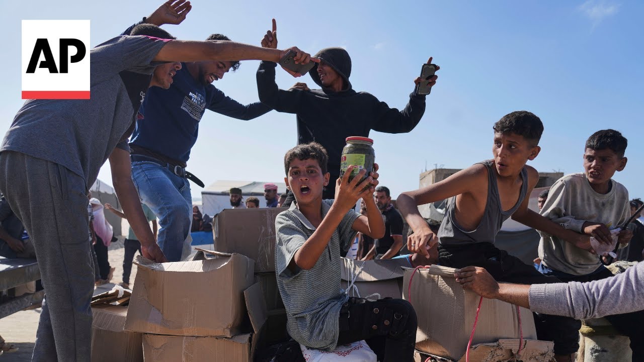 Palestinians pick up aid boxes from newly opened aid distribution ...