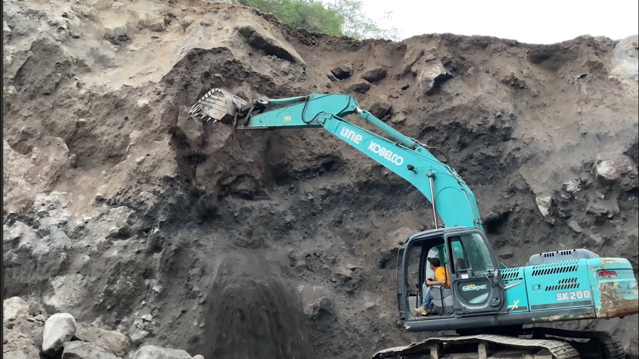 Sand mining | Excavators work to break down large rocks on sand cliffs ...