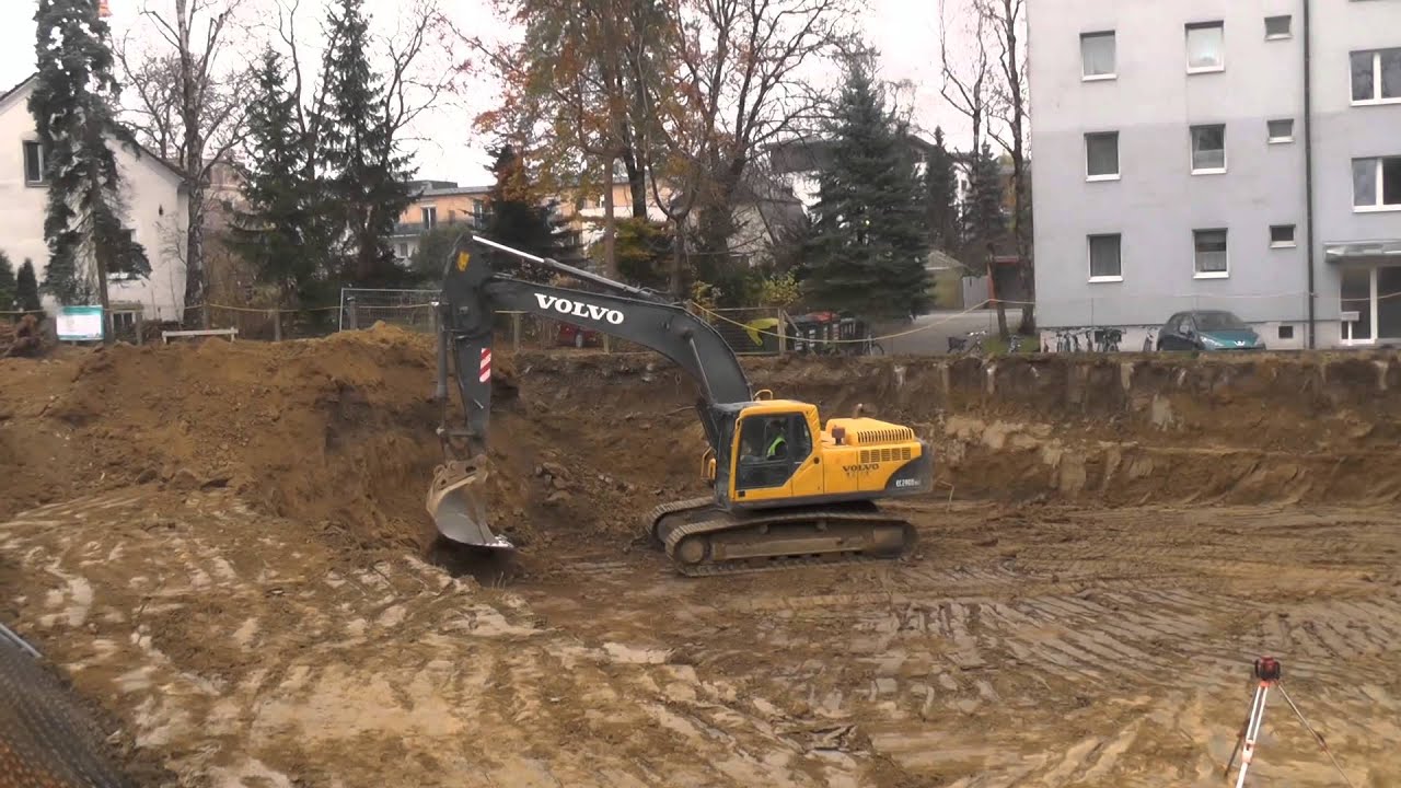 Volvo Bagger belädt 4 Achser MAN LKW fährt aus und ein in der Baugrube ...