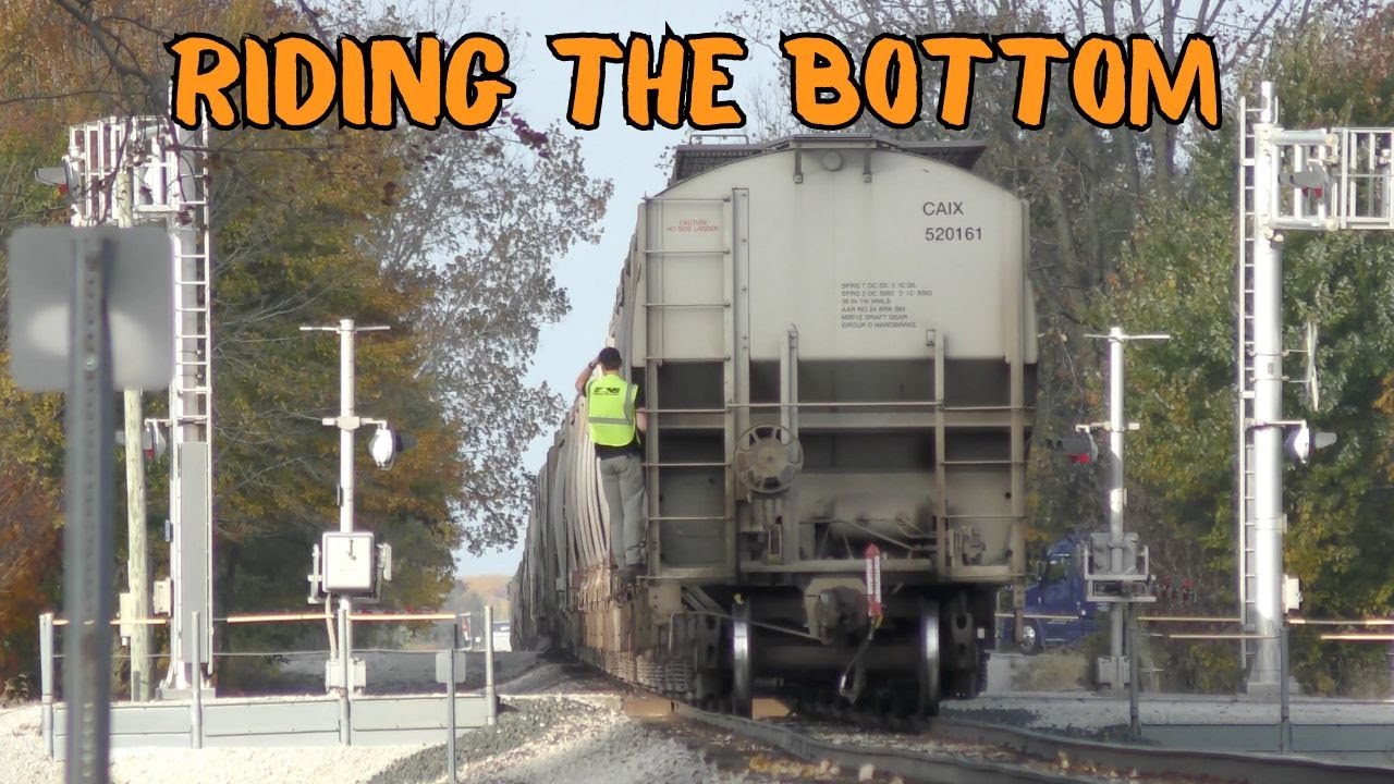 The conductor jumps on the bottom of the train to go deliver cars to a ...