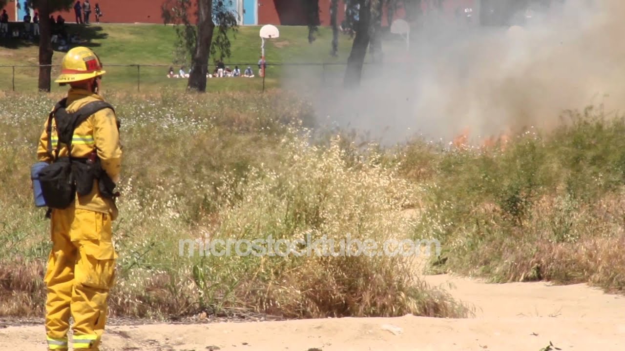 Fireman setting dry grass on fire on purpose - YouTube