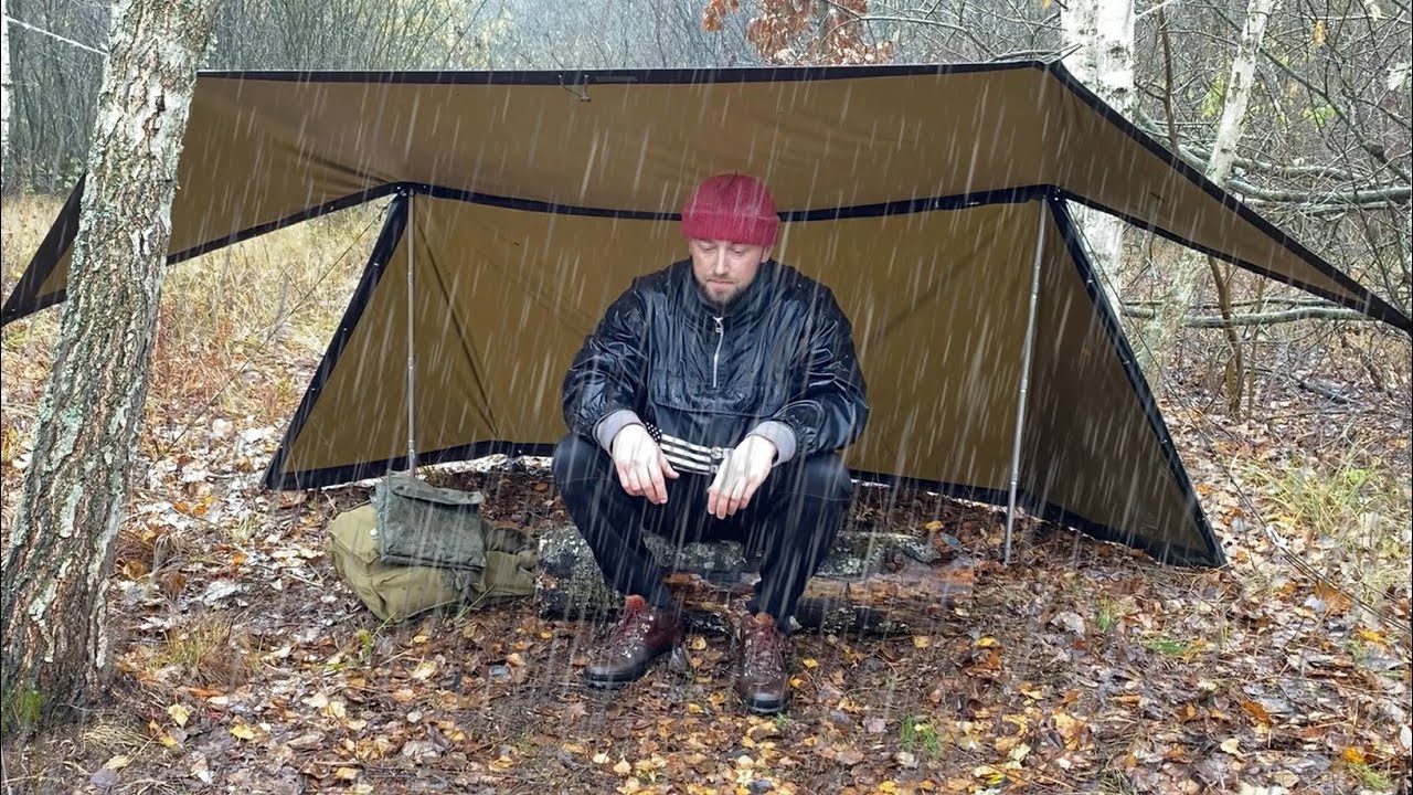 Under a tarp tent in the rain. Cooking burgers on a camping stove ...