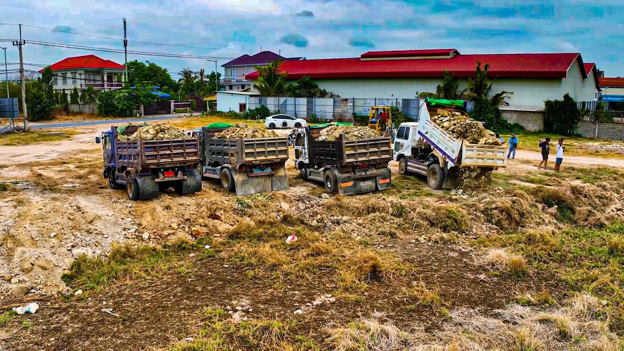 Amazing Many Dump trucks dumping soil Rock fill up land Pushing by ...