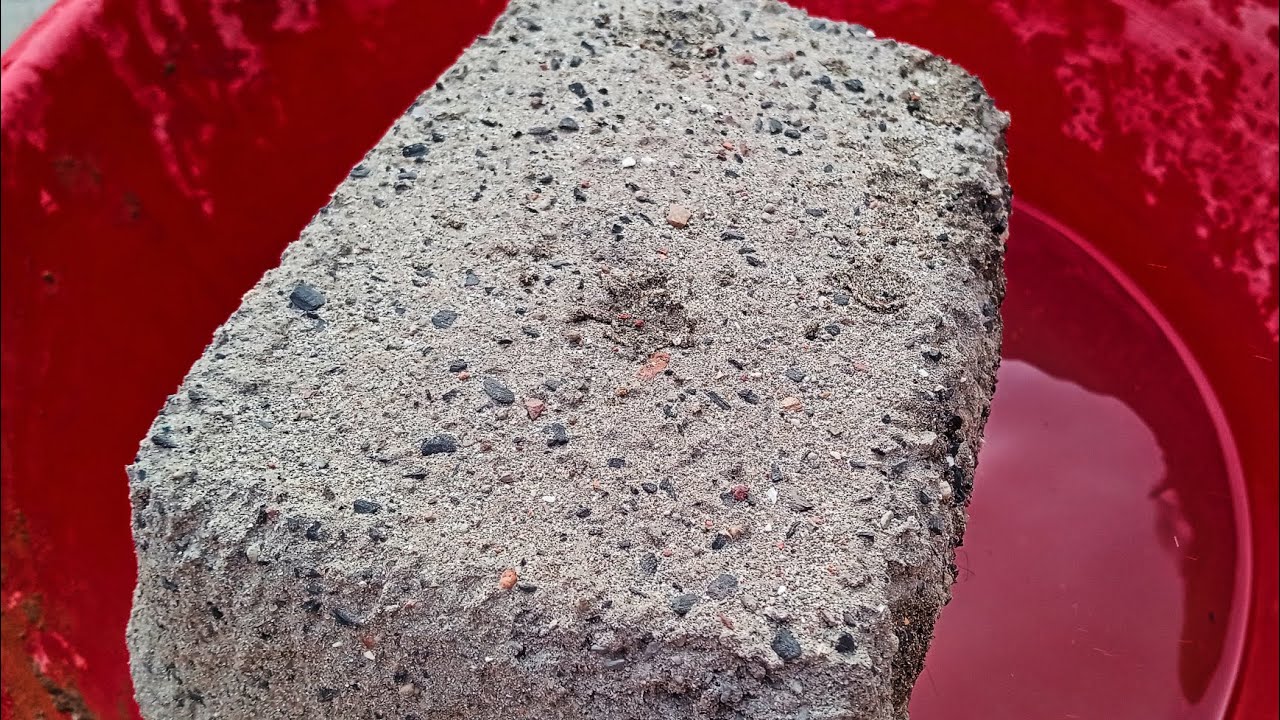 Huge soft blocks of black charcoal chips sand crumbling in water with ...