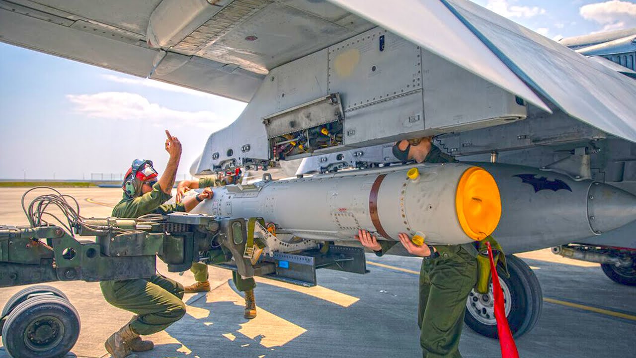 U.S. Marines load ordnance onto F/A-18 Hornet aircraft at Andersen Air ...