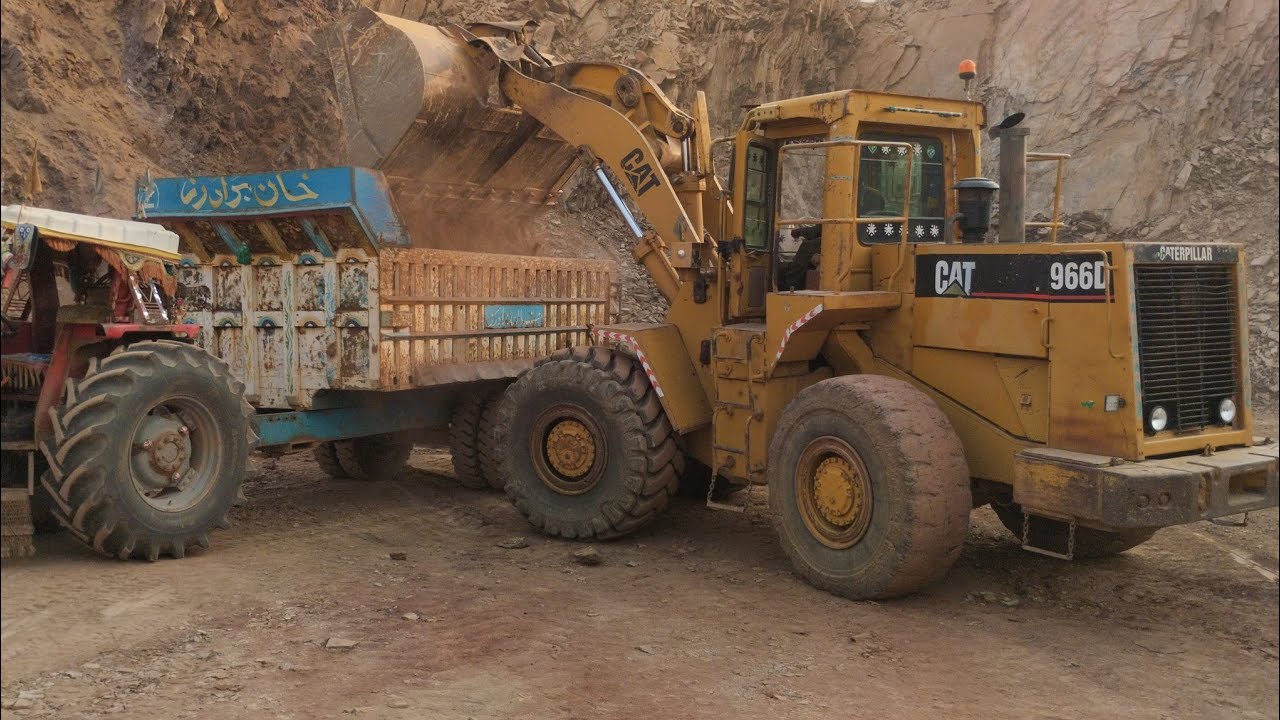 Caterpillar 966D Wheel Loader Loading Rock On Tractor Trolleys - YouTube