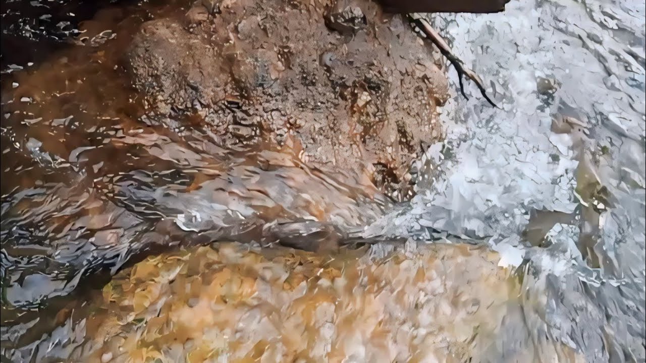 Sound of flowing rocky river - there are faint sounds of birds ...