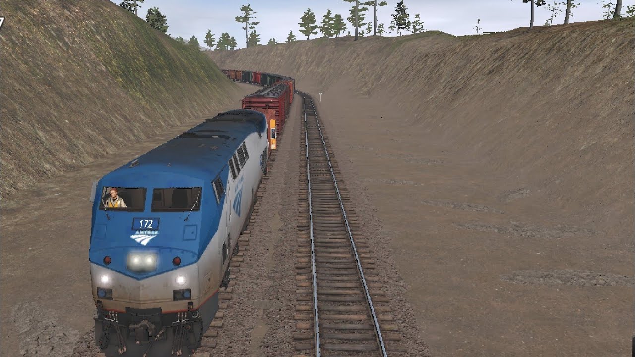 Amtrak tractor goes through a big bend with cargo wagons and the ...