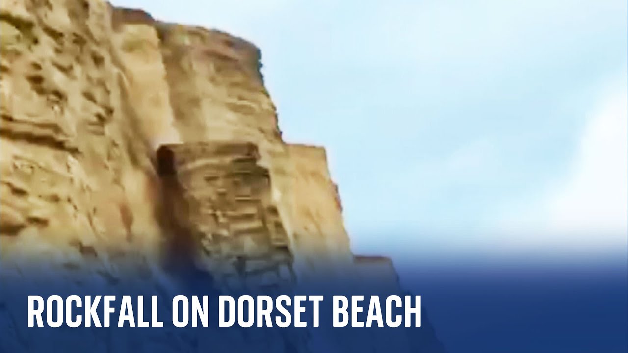 Dorset: Rockfall on a beach narrowly misses people walking below - YouTube