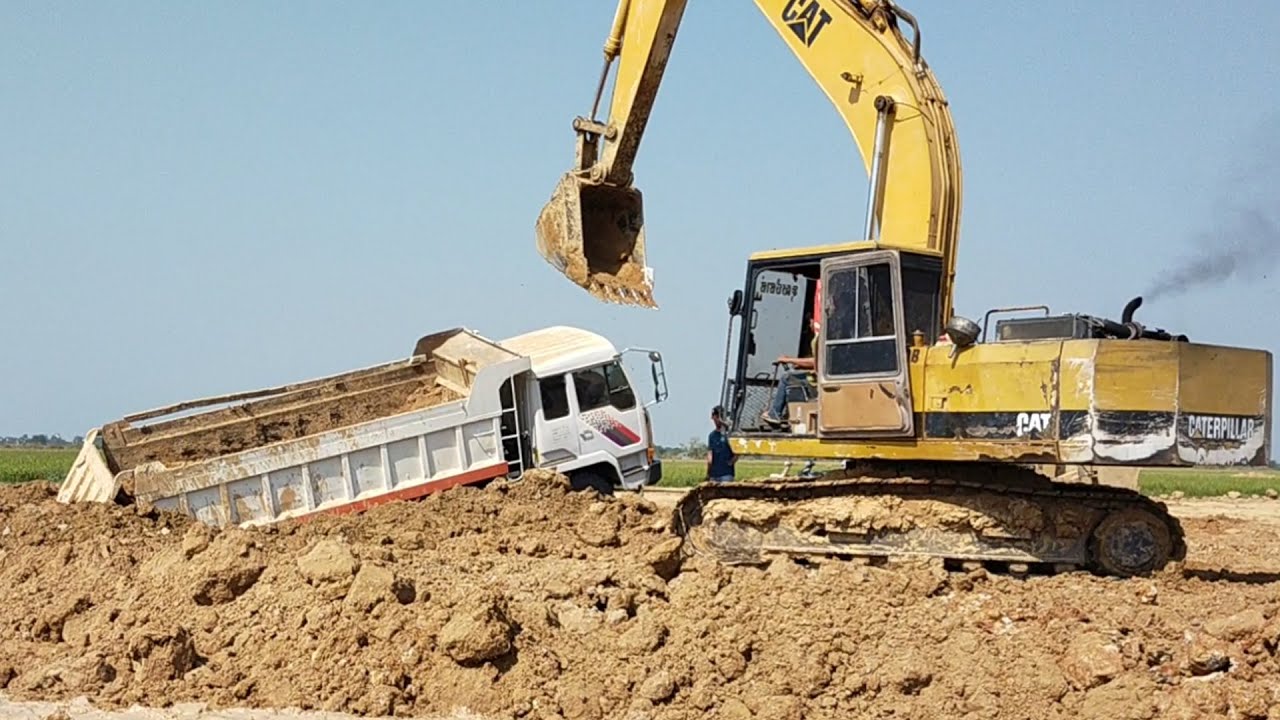 Excavator helps the truck stuck in mud heavy recovery cat Excavator ...
