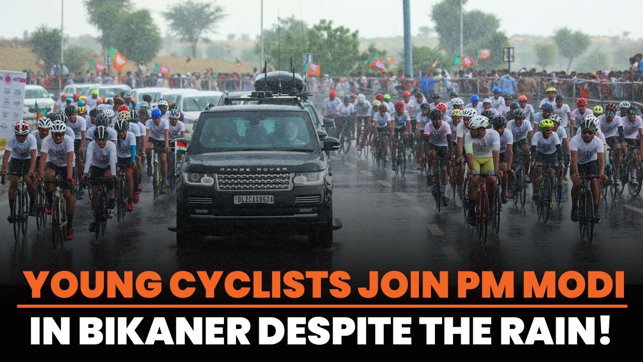 PM Modi's convoy rides along a platoon of cyclists during the roadshow ...