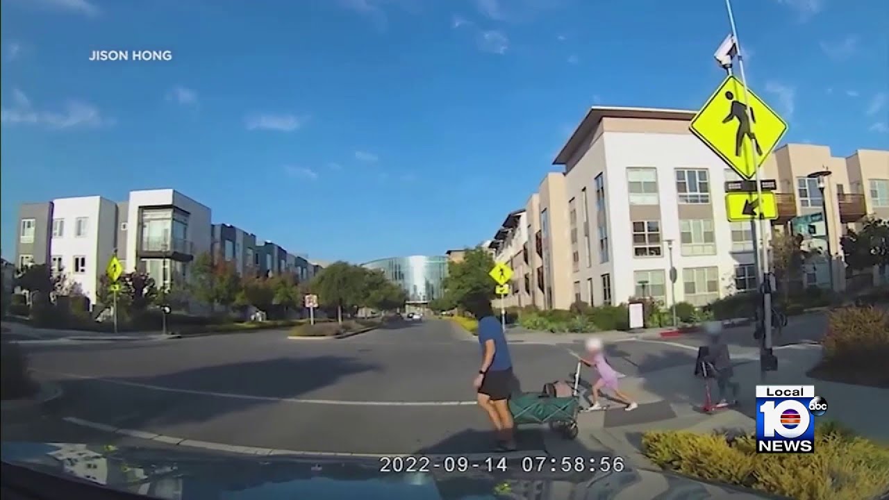 A little girl is almost hit by a car while trying to cross the street ...