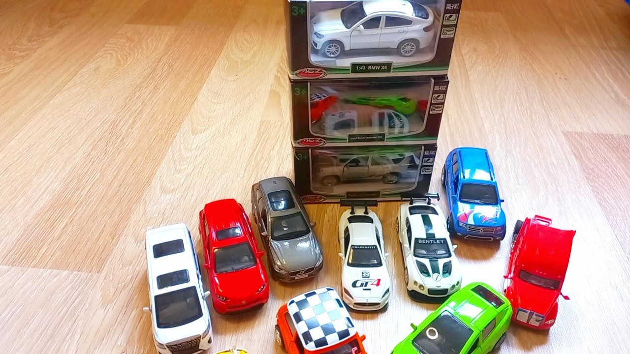 Unpacking cars. Overview of colored bright small cars. Unboxing new ...