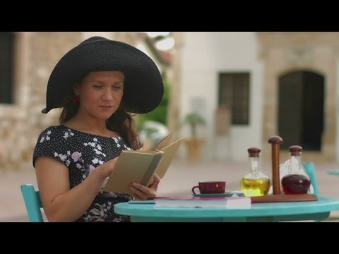 Pretty woman reading old paper book in cafe, enjoying rest, relaxing on vacation. Stock Footage