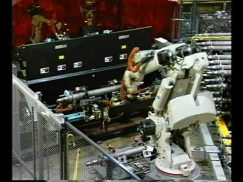 Motoman robot loads axles and brackets into robotic welding cell - YouTube