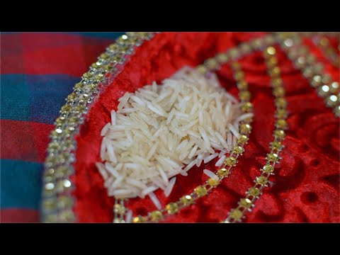 Closeup shot of a girl picking up raw rice from pooja thali | Indian Stock Footage | Knot9