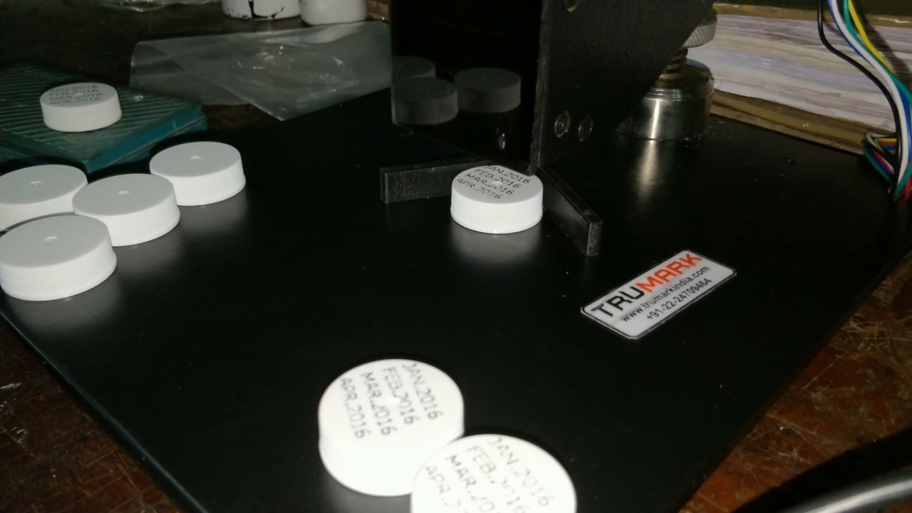 Table top batch coding machine - printing on caps - YouTube